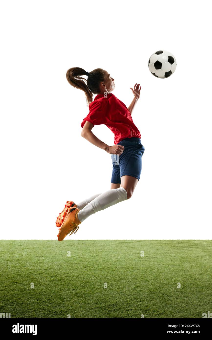 Female athlete, soccer player jumping in mid-air to hit ball with chest ...