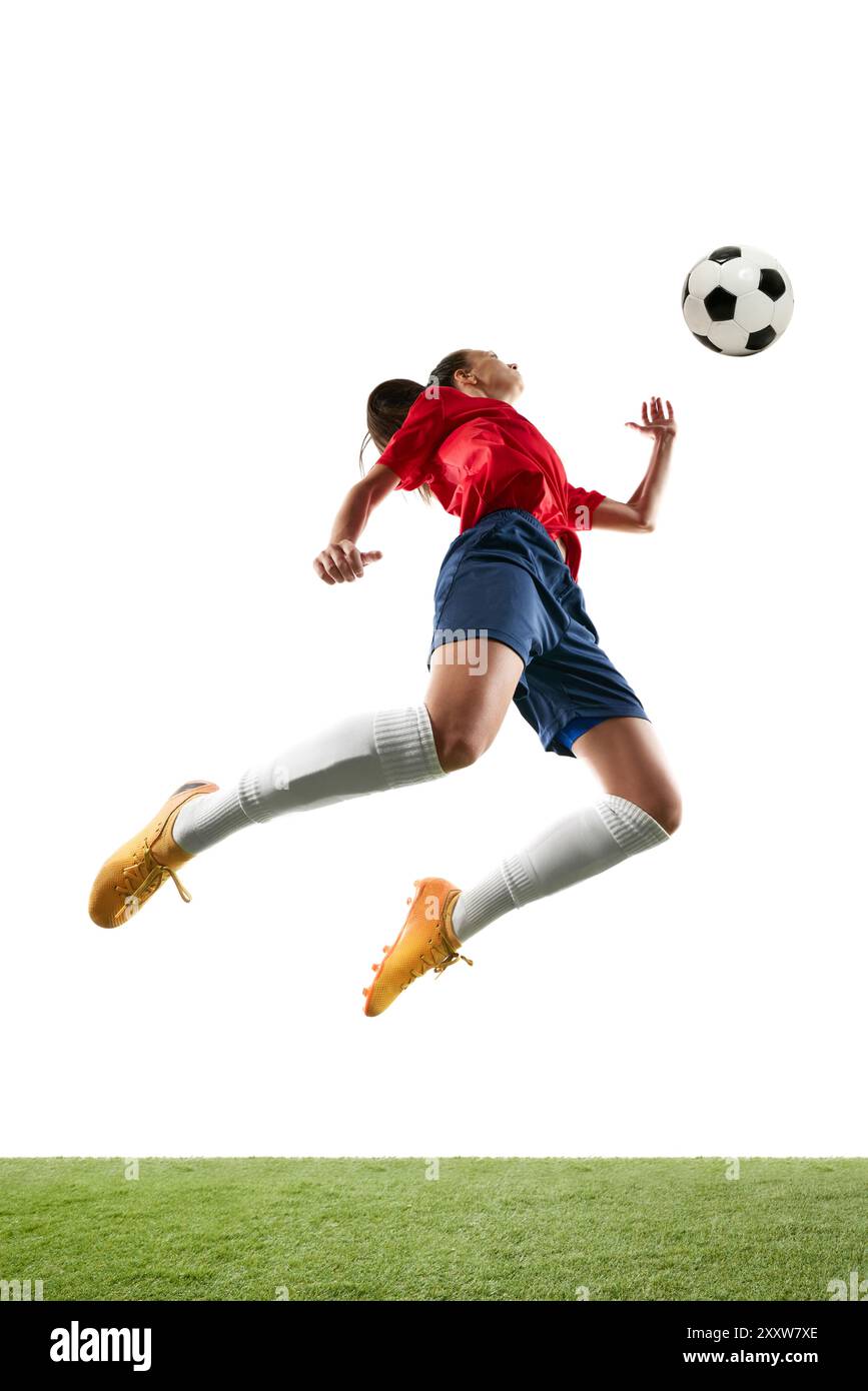 Tall female soccer player leaping in mid air to hitting ball with chest ...