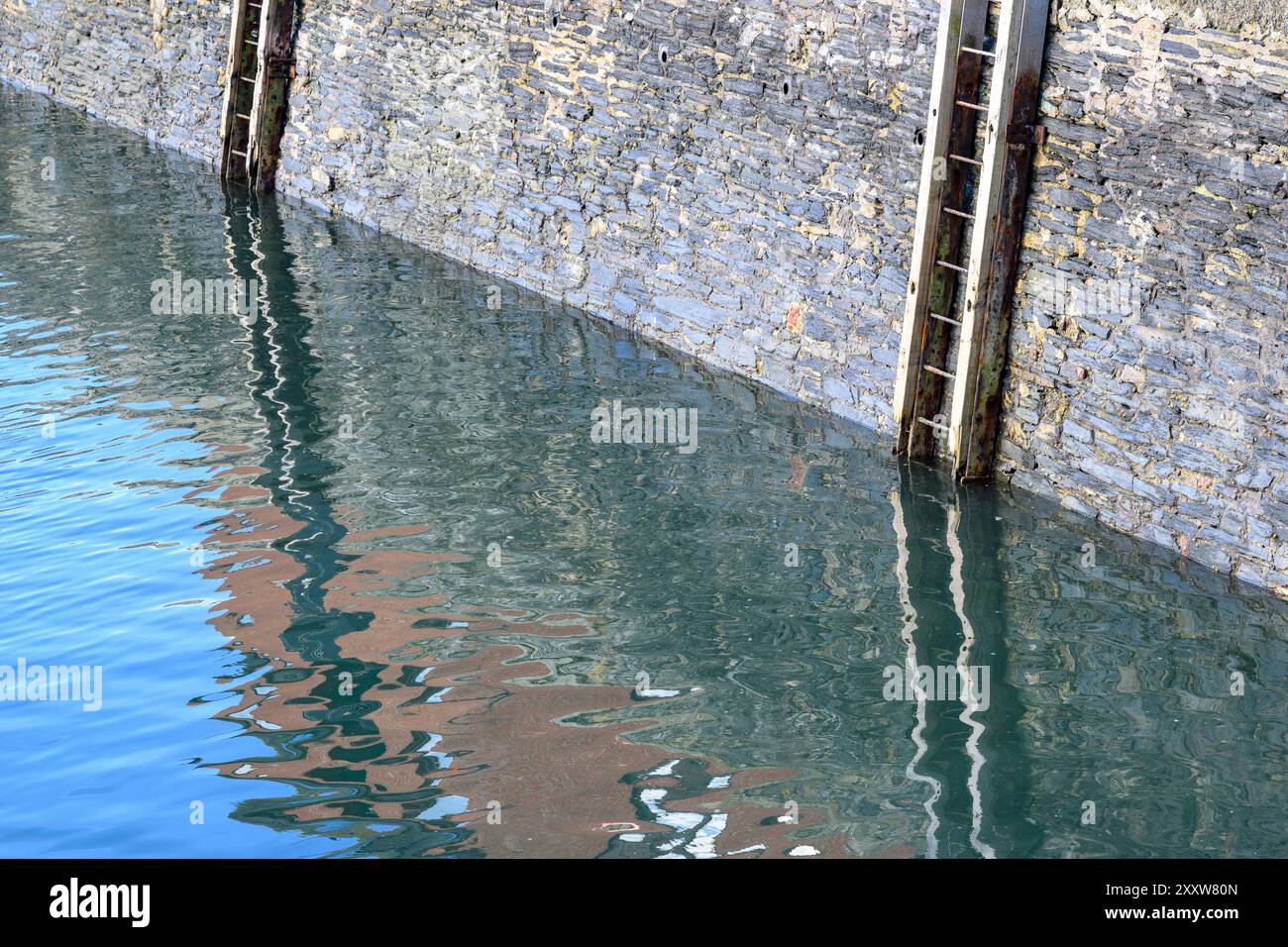 Harbour ladder reflected in water Stock Photo - Alamy