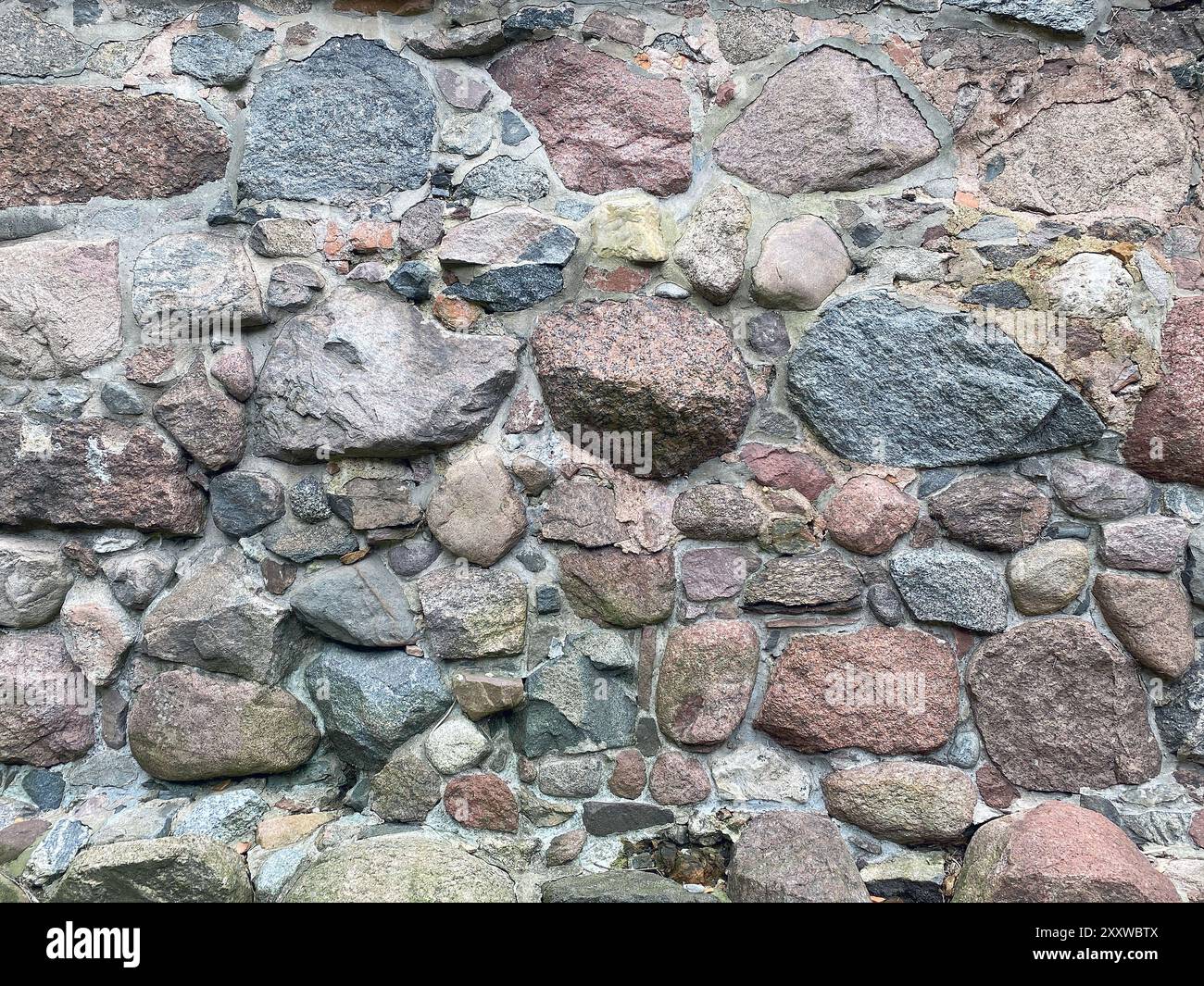 Stone wall with different colors and size of rocks Stock Photo - Alamy