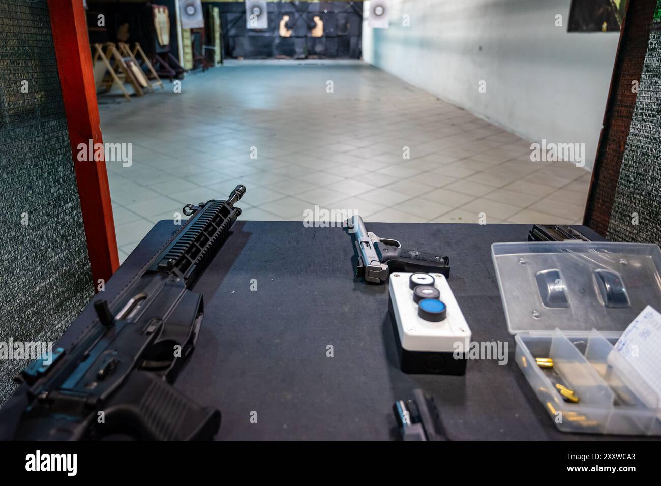 guns, rifle, pistols and bullets laid out on the table at a shooting ...