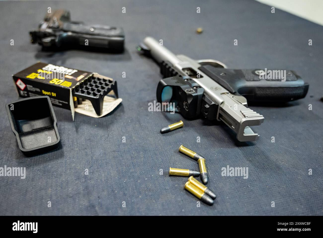 guns, rifle, pistols and bullets laid out on the table at a shooting ...