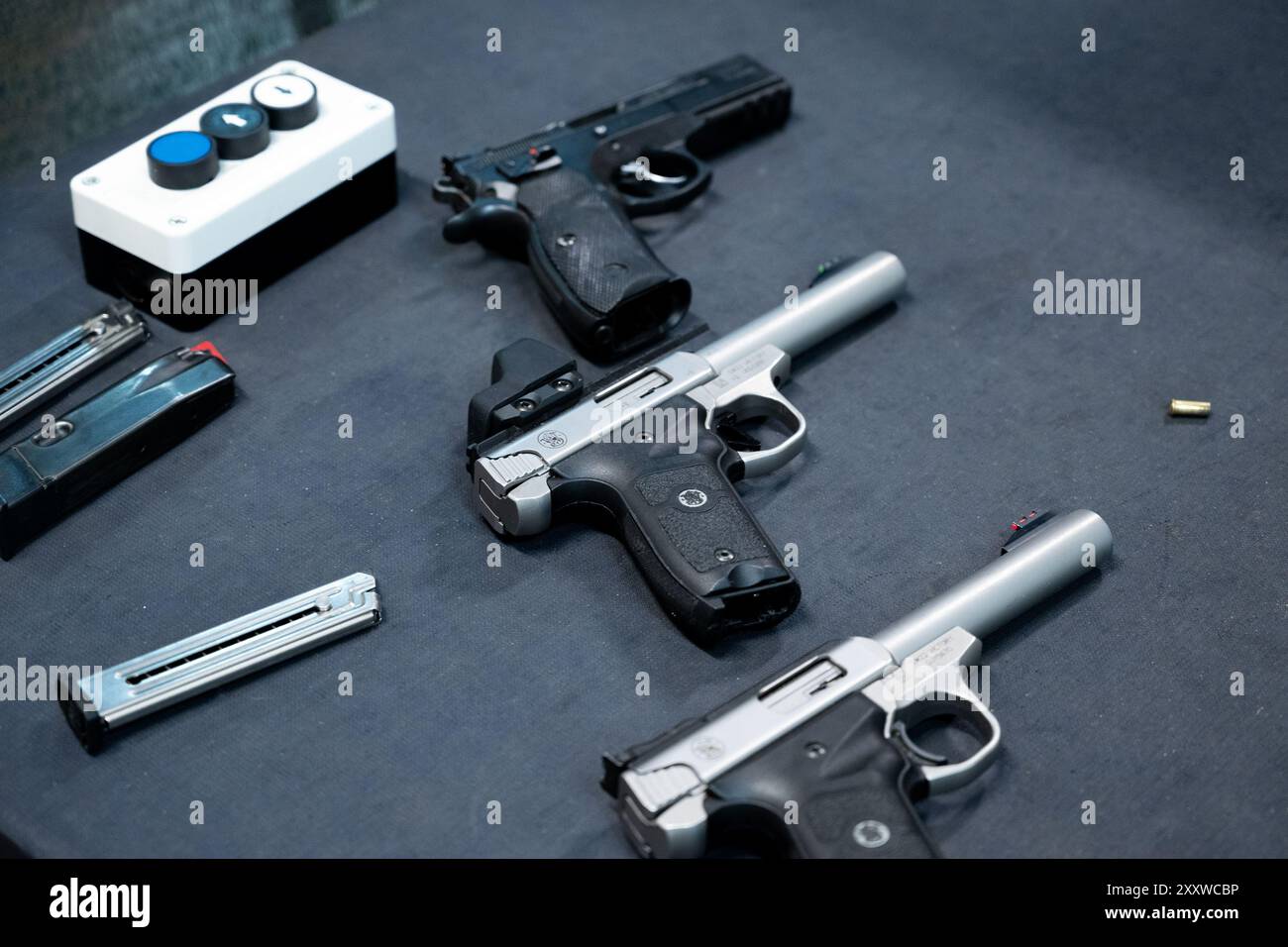 guns, rifle, pistols and bullets laid out on the table at a shooting ...