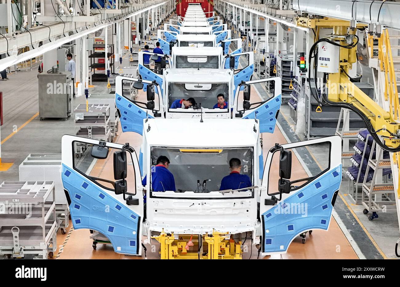 People work on the assembly line of electric trucks at the parking lot ...