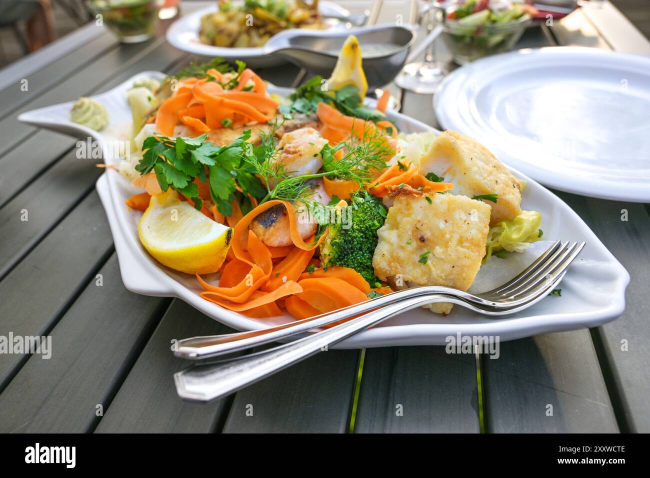 White platter in fish shape with various fried fish fillets and ...