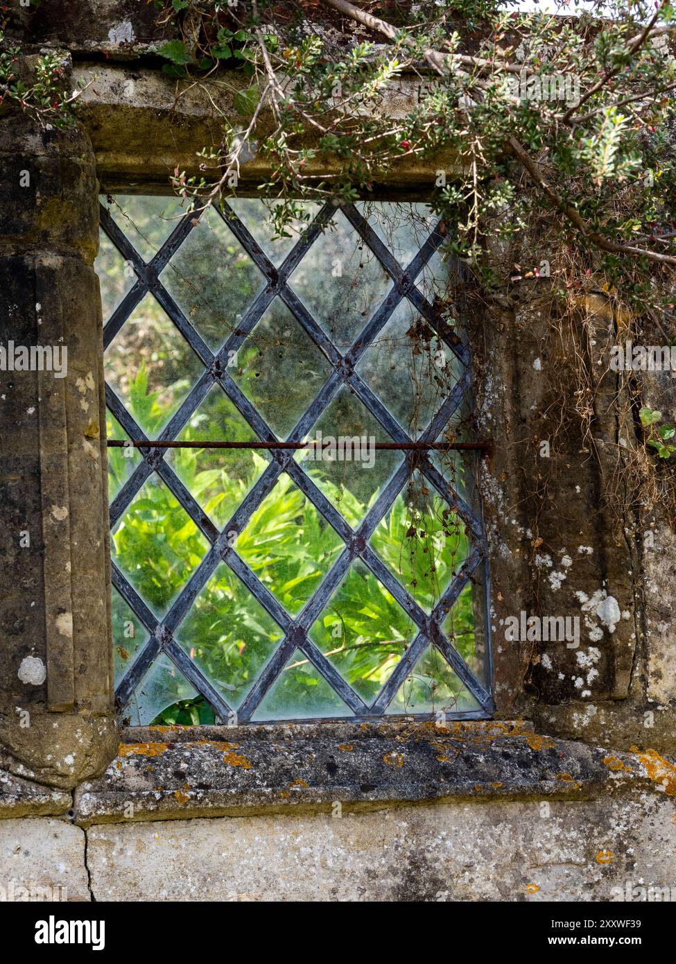 Decaying old window frame in a ruined building, lead windows are still ...