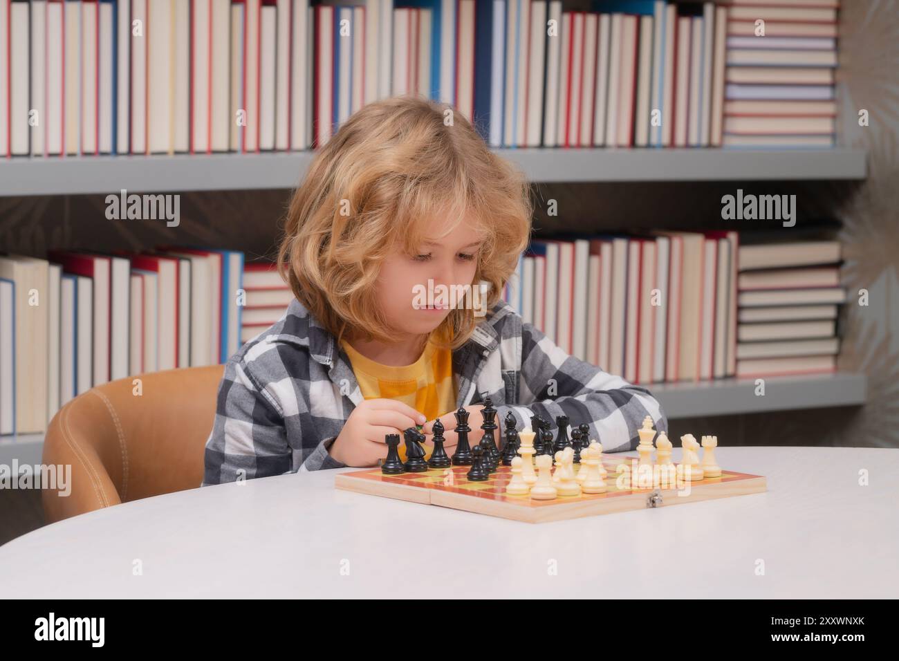 Kid play chess in classroom at school. Little kid play chess. Thinking ...