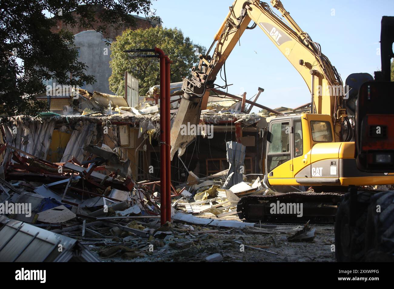 Demolition of buildings with a hydraulic excavator. Demolition of a ...