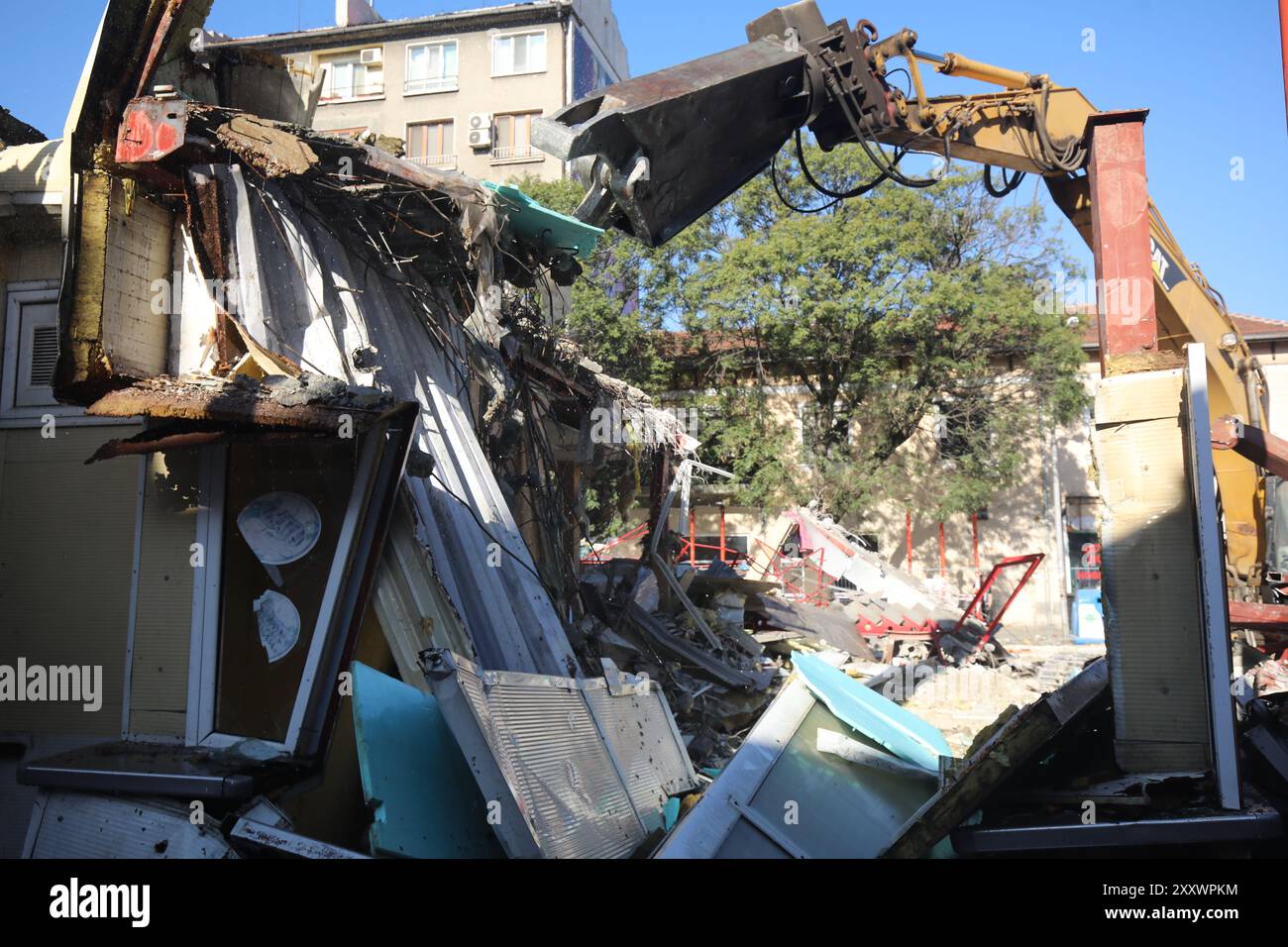 Demolition of buildings with a hydraulic excavator. Demolition of a ...