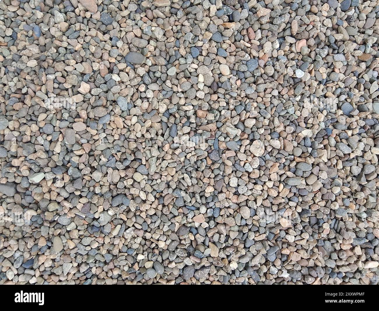 This image captures a vast array of small, multi-colored pebbles filling the frame with a ...
