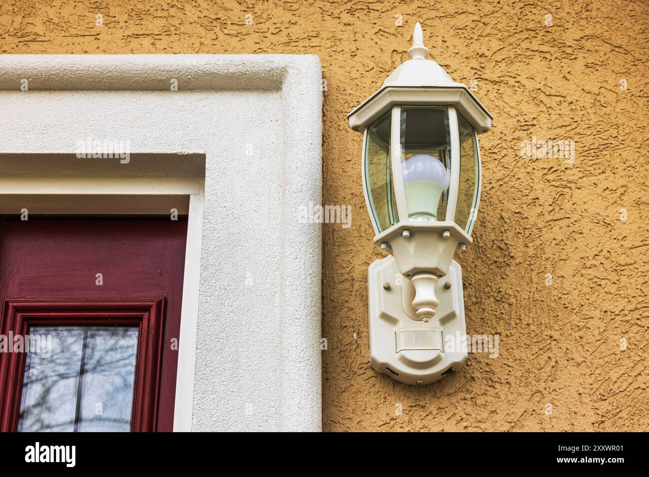 Close up view of plaster wall with a built-in ornate lantern, yellow ...