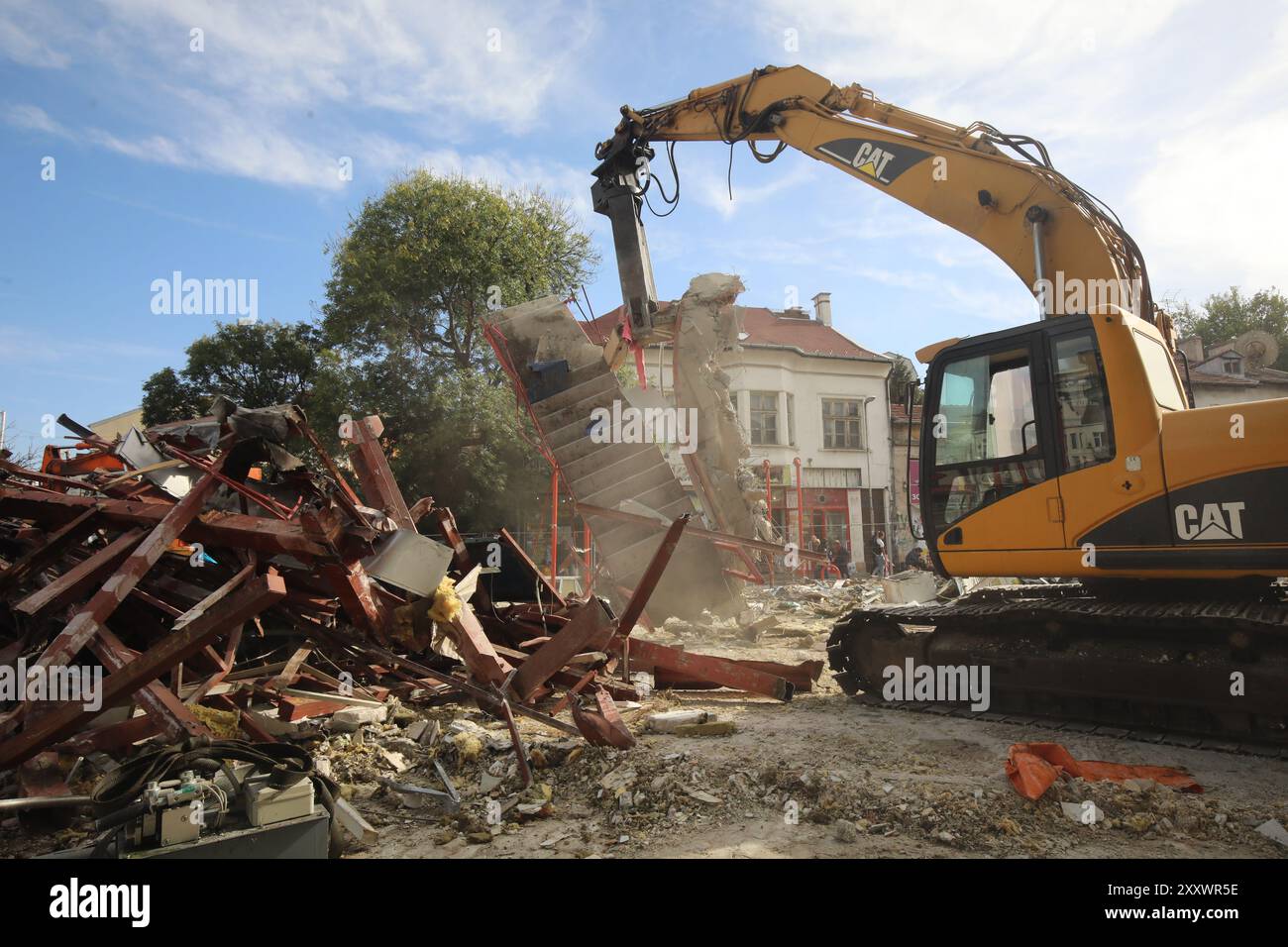 Demolition of buildings with a hydraulic excavator. Demolition of a ...