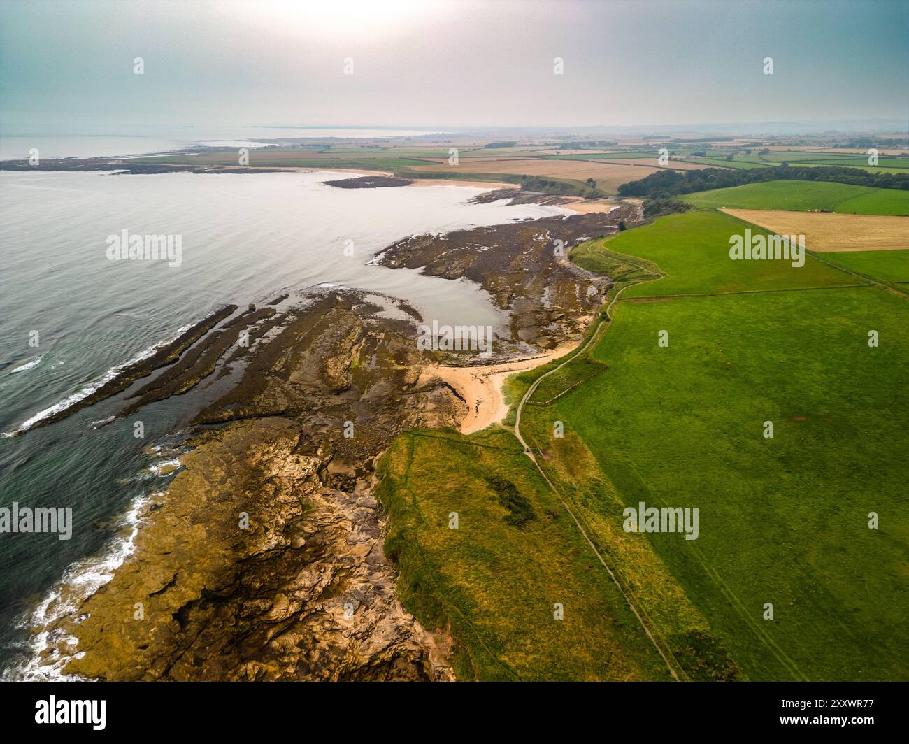 The drone captures an expansive view of Longhoughton Beach, featuring ...