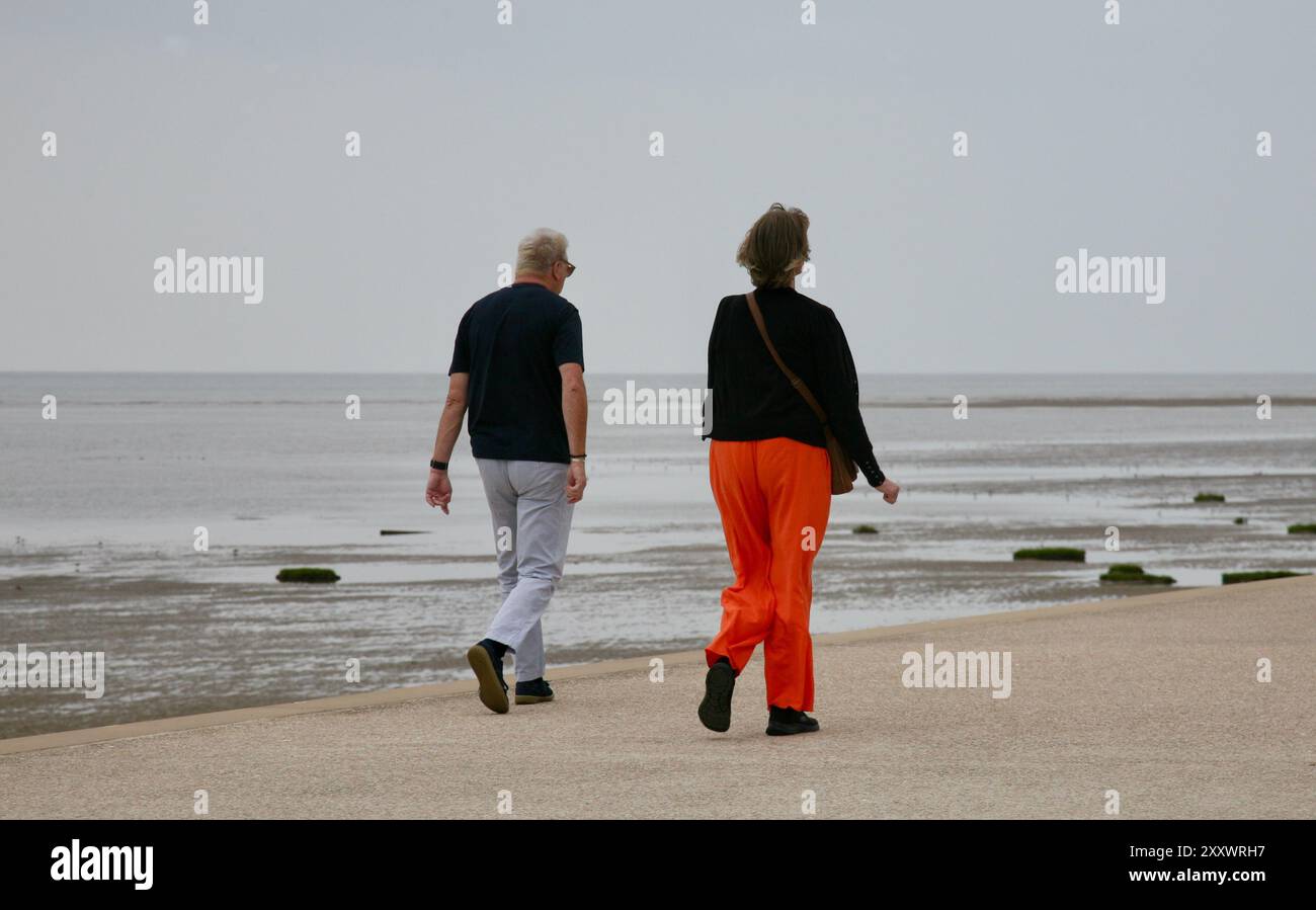 A couple strolling along on the seafront Stock Photo - Alamy