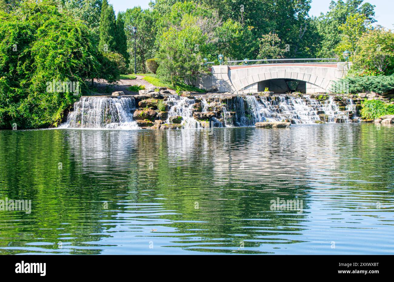 Manmade waterfall and pond with vehicle bridge Stock Photo - Alamy