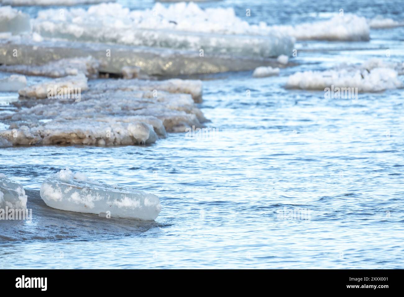 Fragments of melting ice mixed with sand floating on Baltic Sea water ...