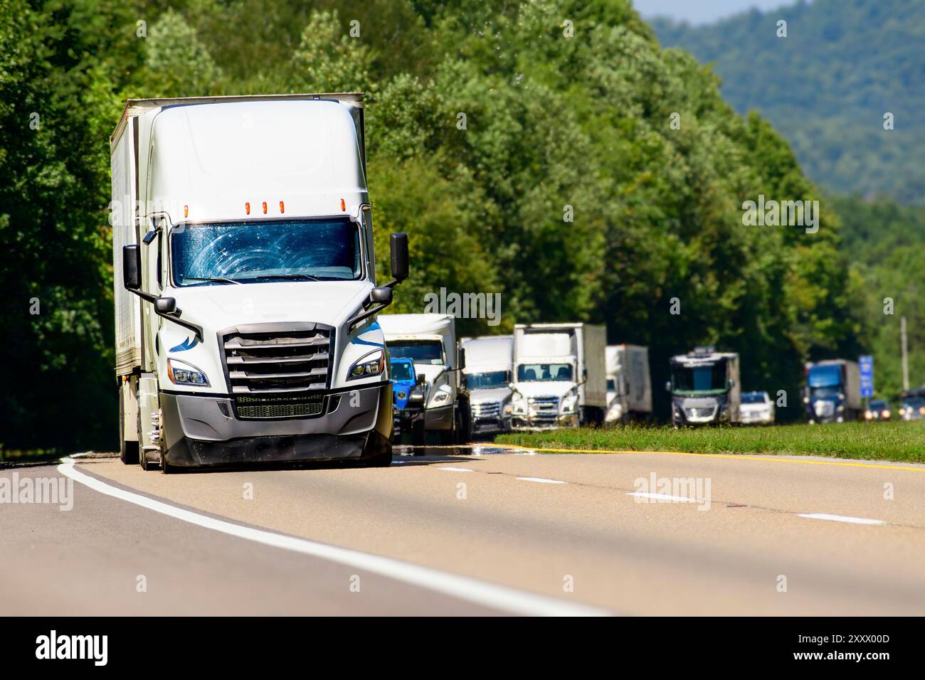 Horizontal shot of a long line of summer traffic on a busy interstate highway. Heat waves rising ...