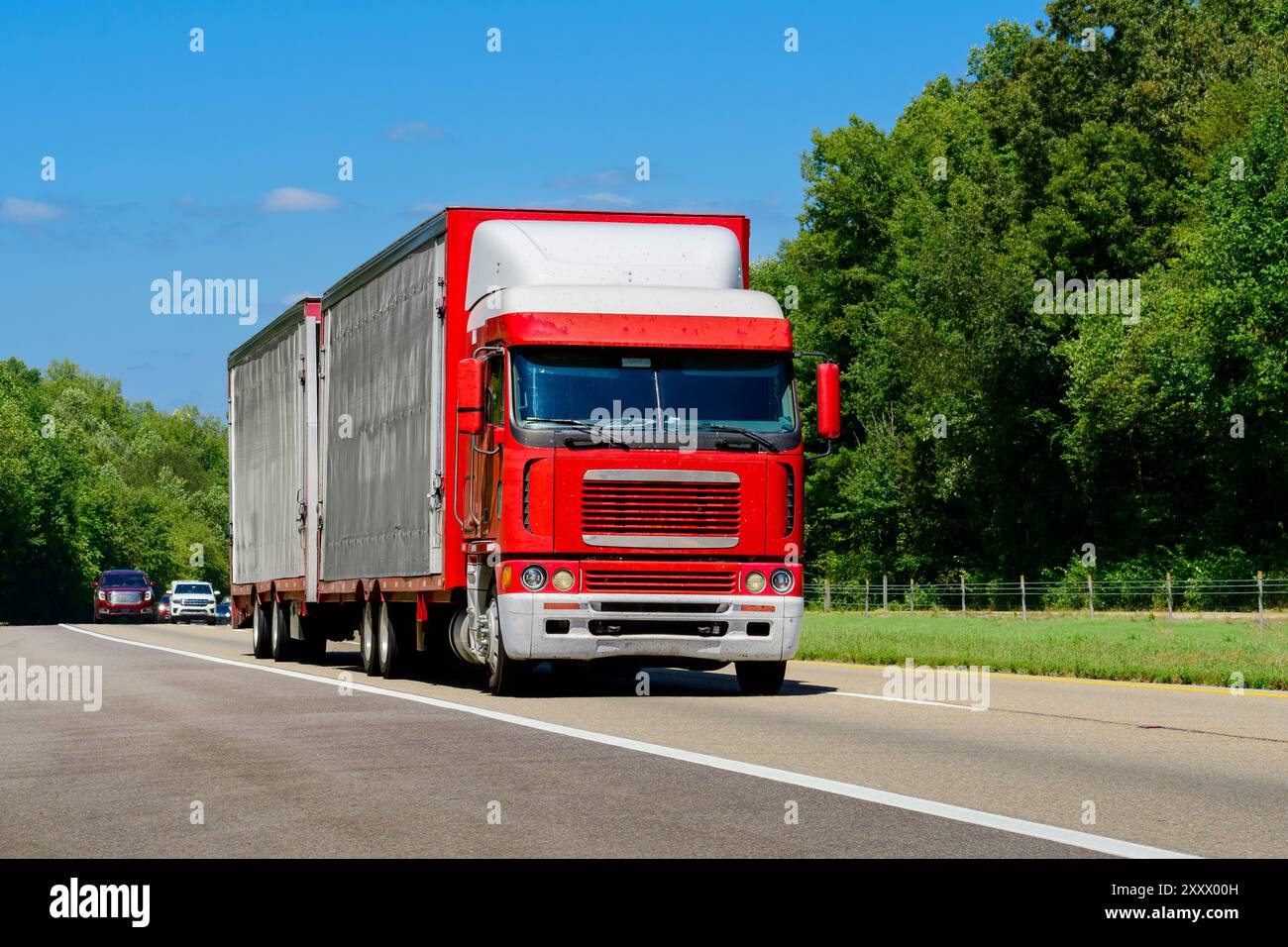 Horizontal shot of a red cab-over semi eighteen-wheeler with dual ...