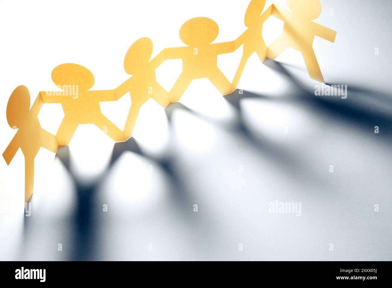 Team of paper chain people united together holding hands Stock Photo ...