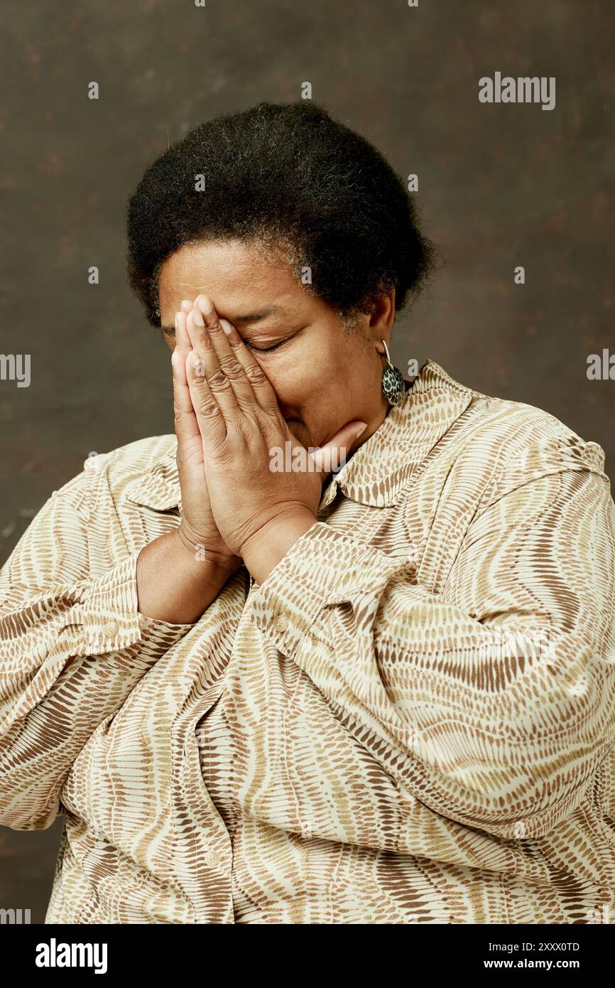 Medium shot of worried elderly African American woman in beige clothes ...