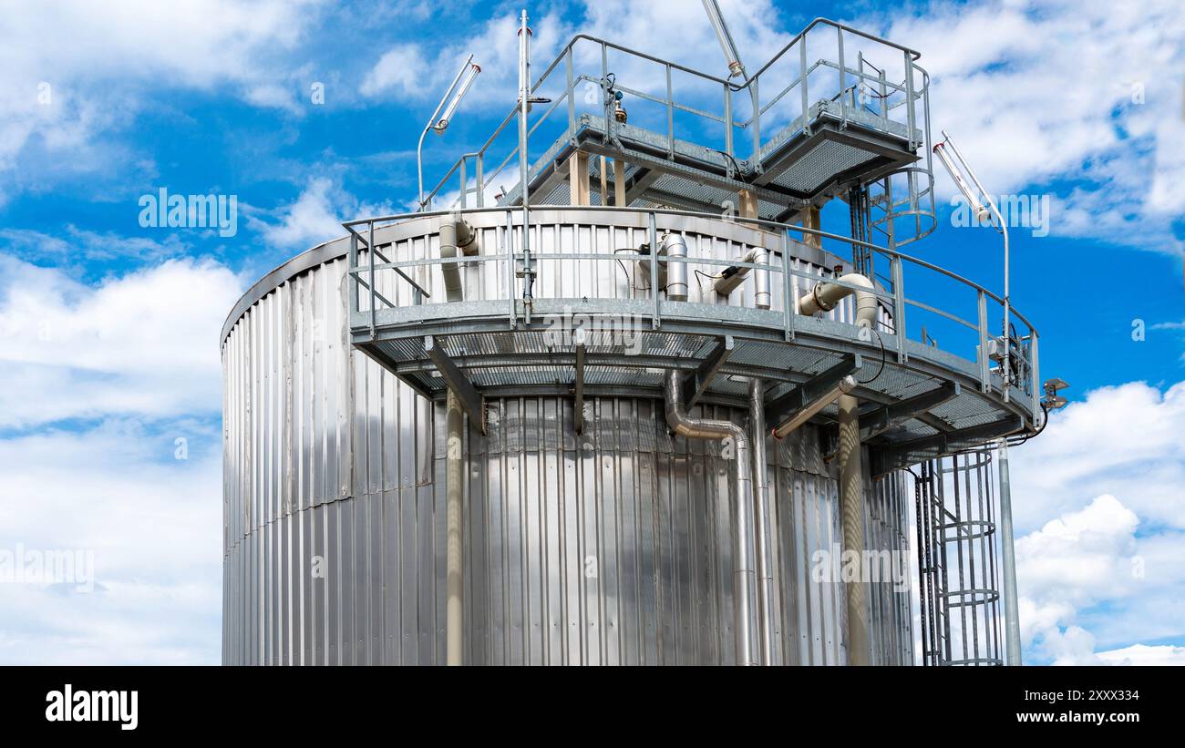 A huge metal tank at a production facility surrounded by pipes Stock ...