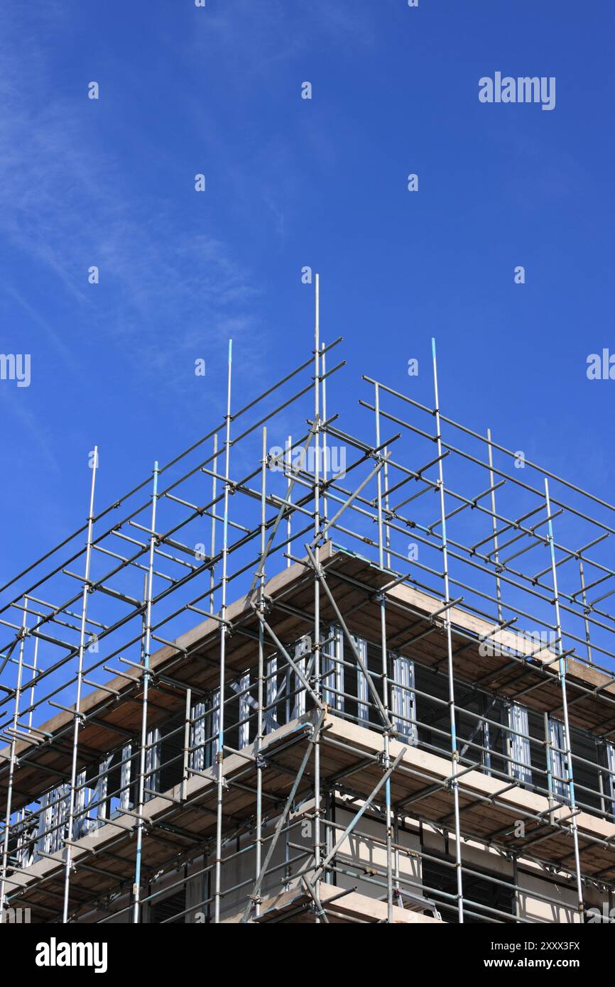 Scaffolding on new mixed development, under construction with blue sky ...