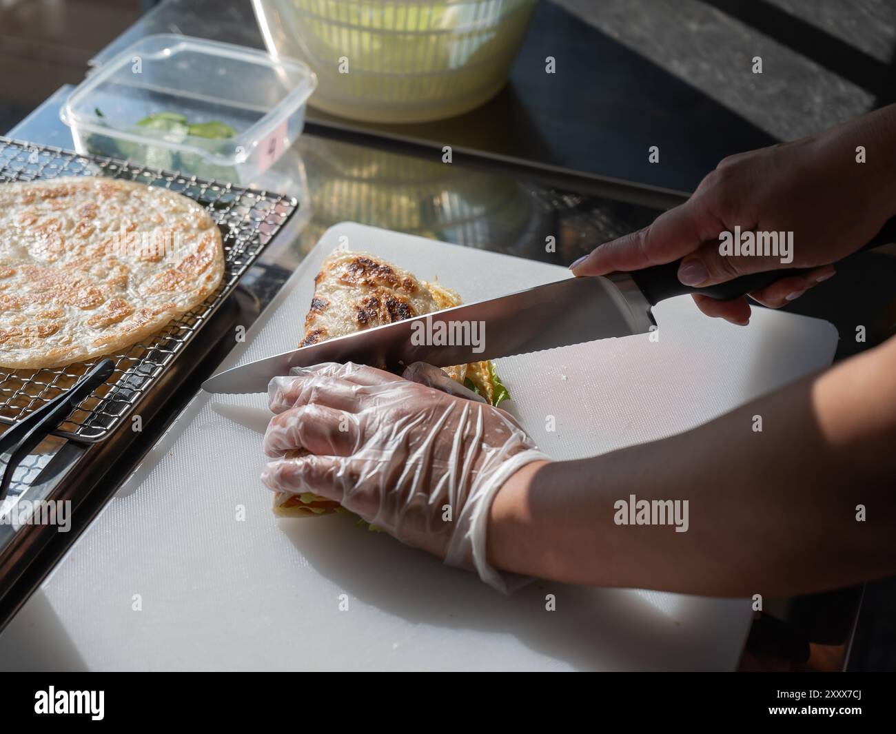 The cook cuts the flatbread with salmon. Quesadilla Stock Photo - Alamy