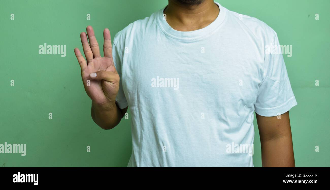 young fair-skinned male keeping hand raised while counting with fingers ...