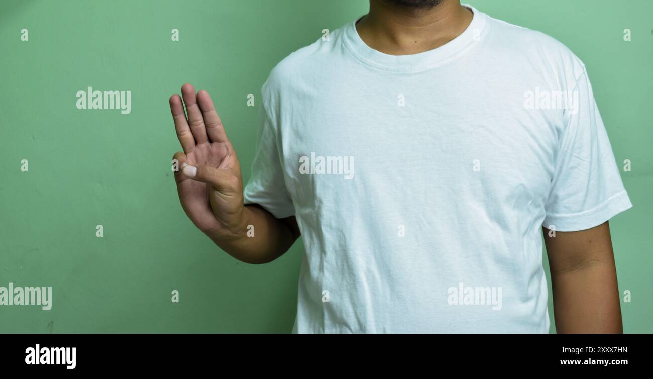 young man keeping hand raised and forming letter W on sign language ...