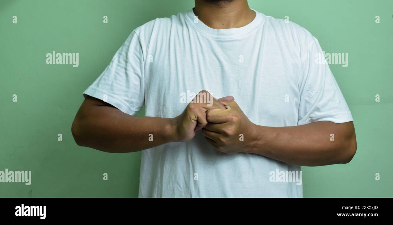 man cracking his knuckles on green background Stock Photo - Alamy