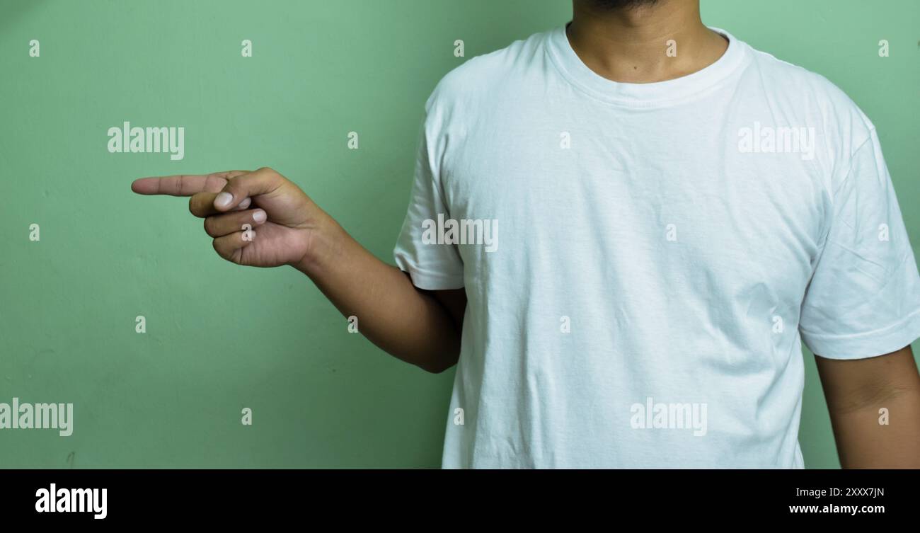 young male pointing aside with forefinger while showing letter G on ...