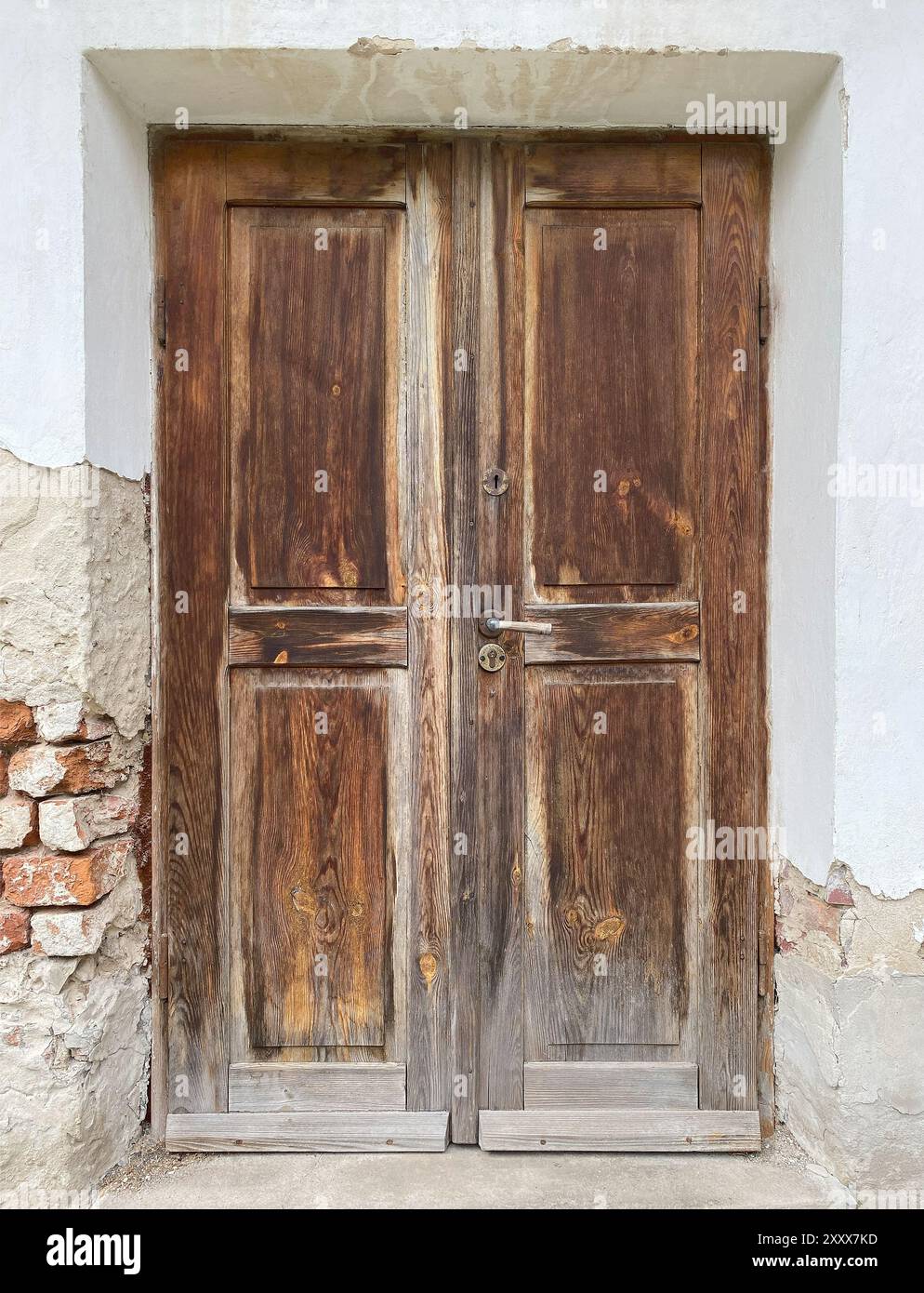 Old wooden damaged brown door of brick building Stock Photo - Alamy