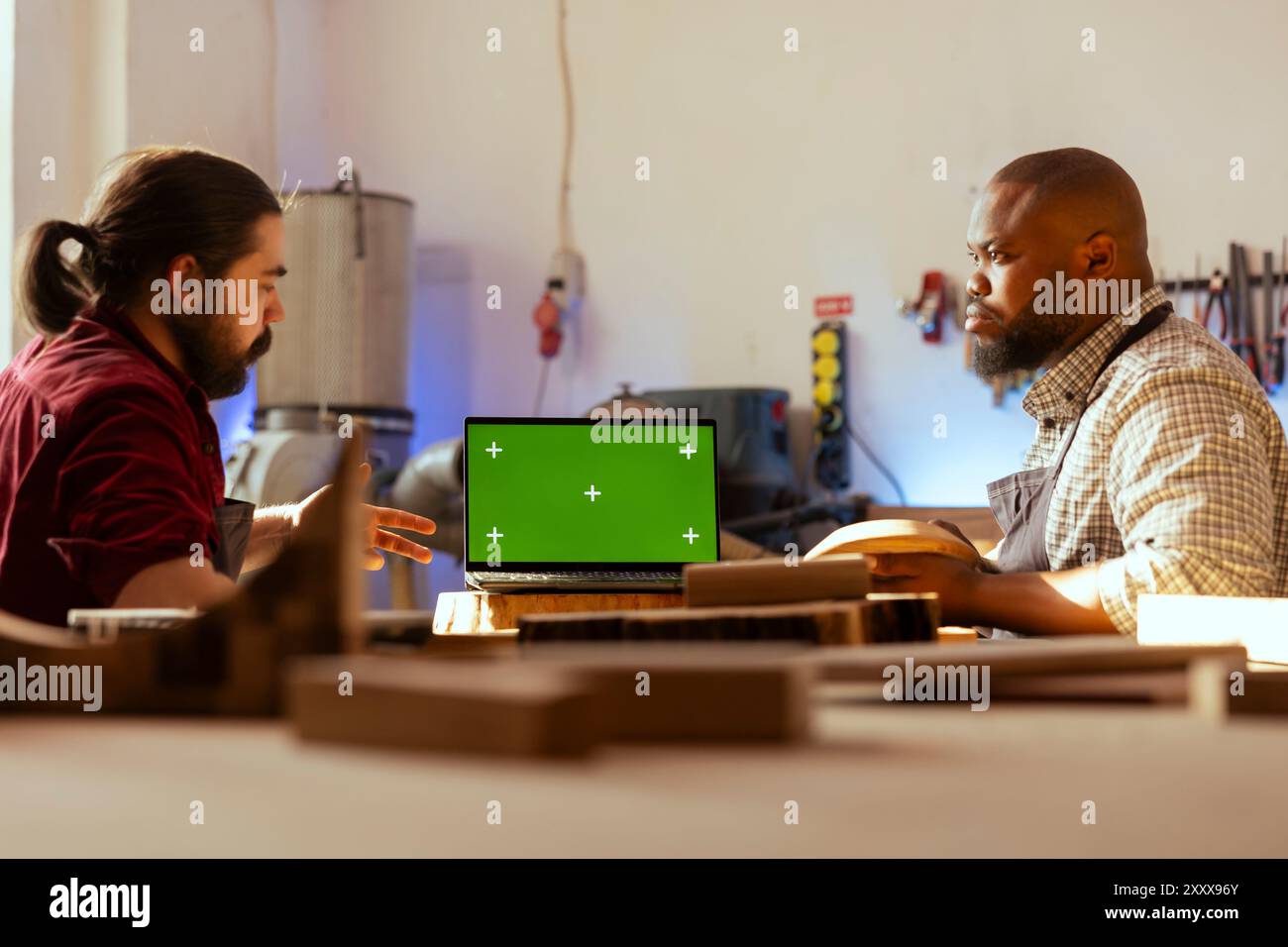 BIPOC artisan and apprentice comparing wood art piece with schematic ...