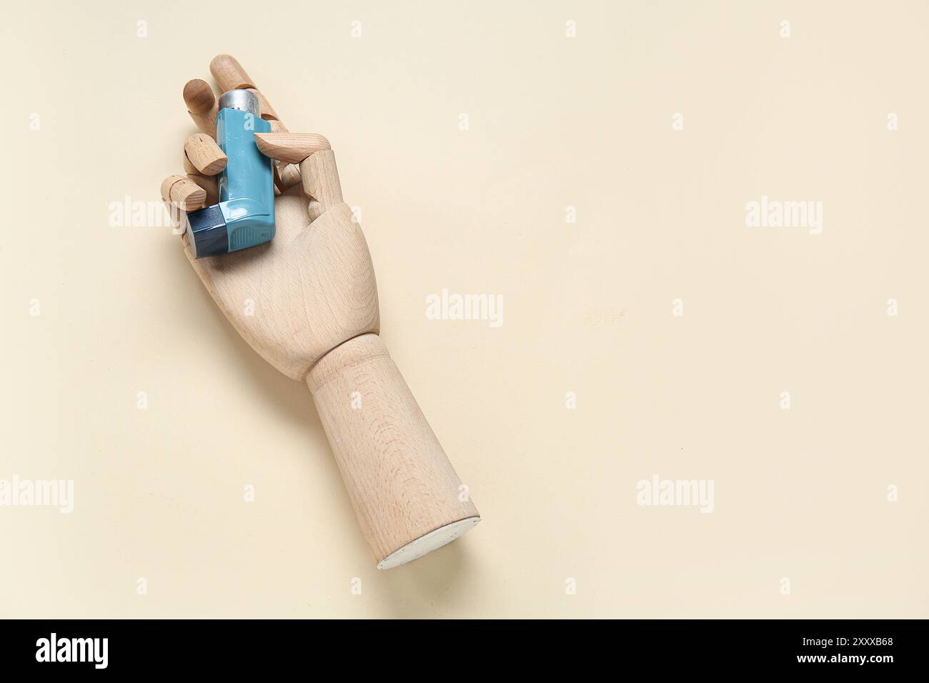Wooden hand with asthma inhaler on beige background Stock Photo - Alamy