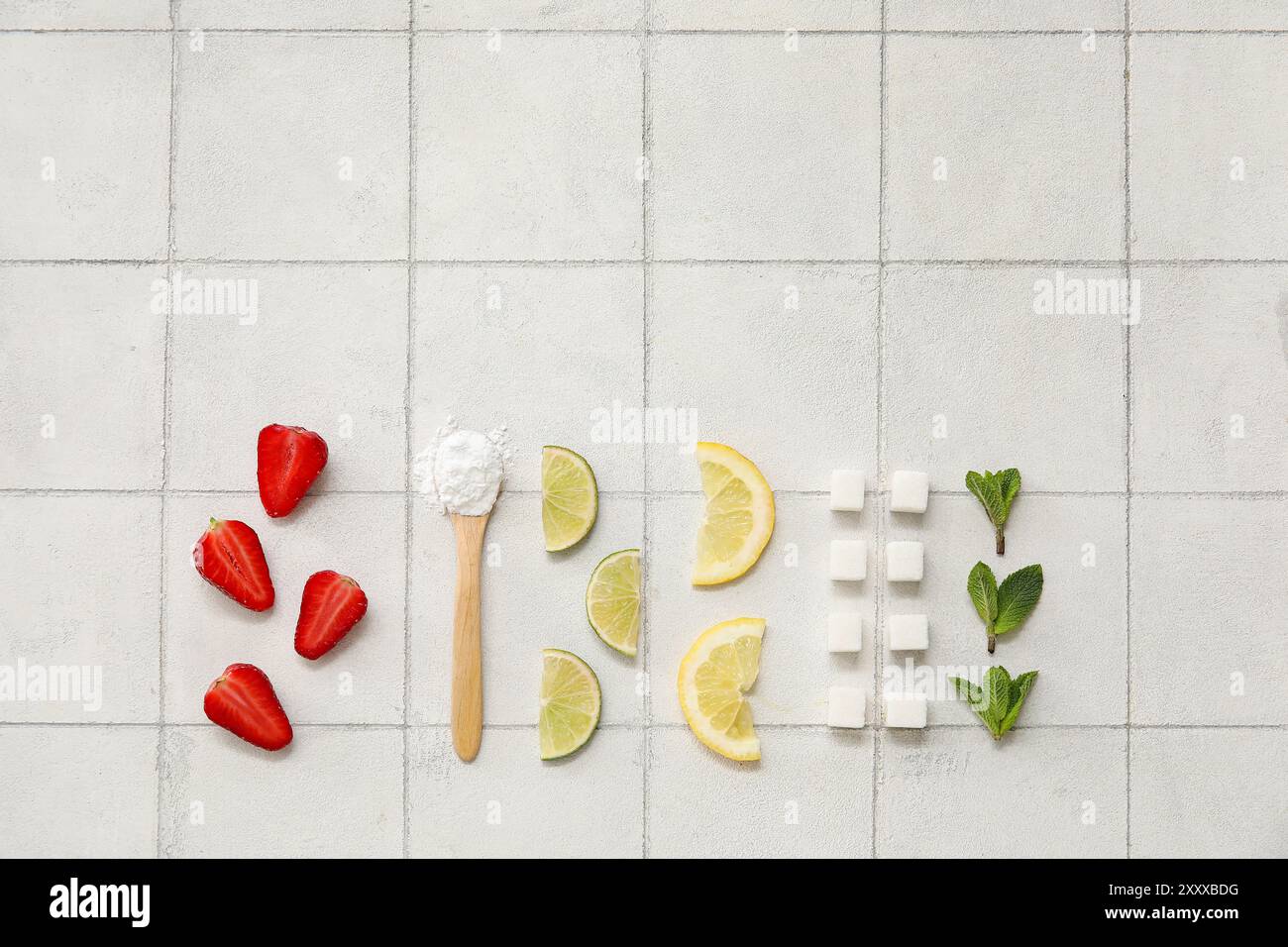 Ingredients for preparing strawberry compote on white tile background ...
