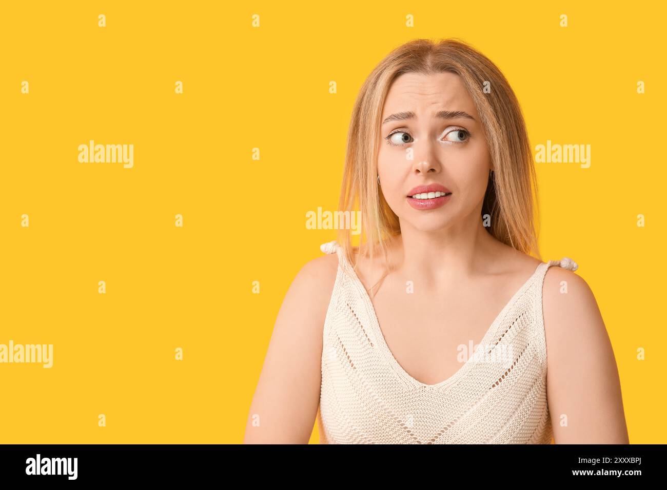 Embarrassed young woman on yellow background Stock Photo - Alamy