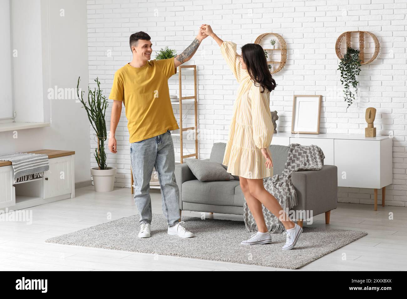 Beautiful young couple dancing at home Stock Photo - Alamy