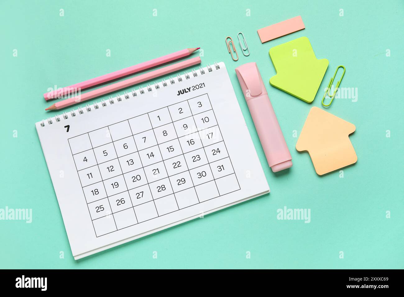 Calendar with office stationery on turquoise background Stock Photo - Alamy