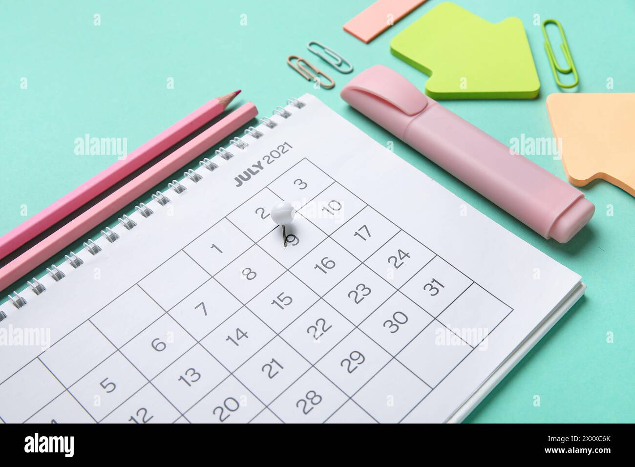 Calendar with office stationery on turquoise background Stock Photo - Alamy
