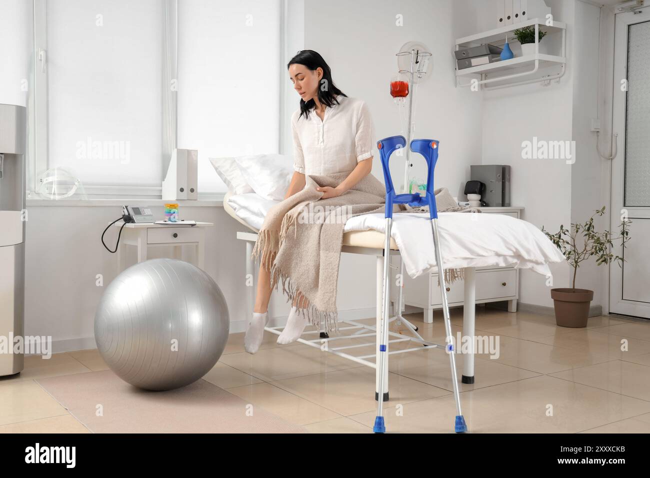 Female patient sitting on bed in hospital ward Stock Photo - Alamy