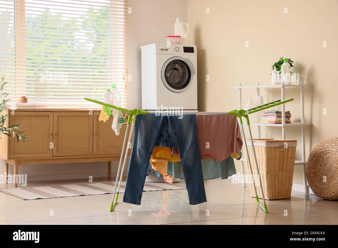 Interior of laundry room with clean clothes on dryer and washing ...