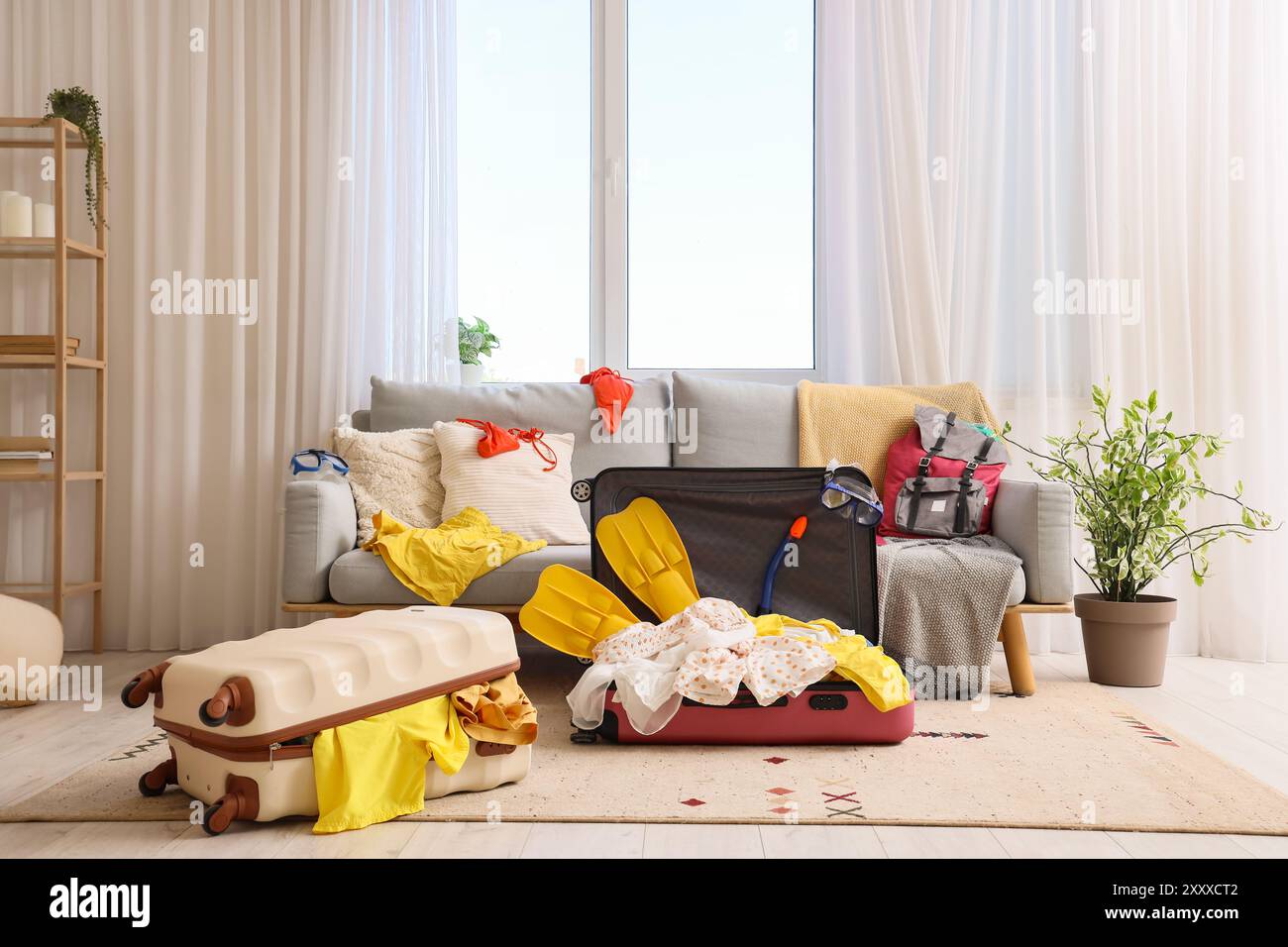 Interior of messy living room with sofa, scattered things and suitcases ...