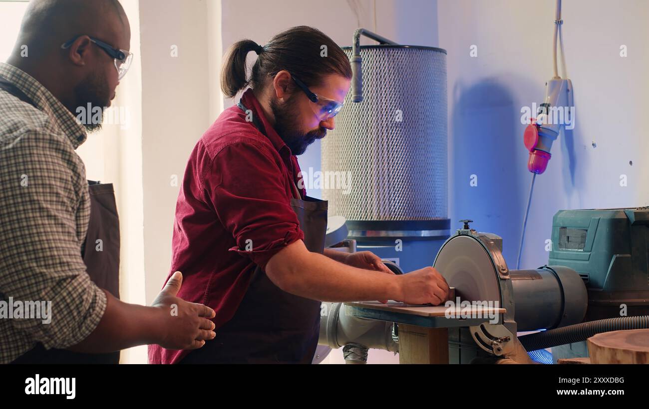 Man teaching african american trainee how to shape wooden bowl on disc ...