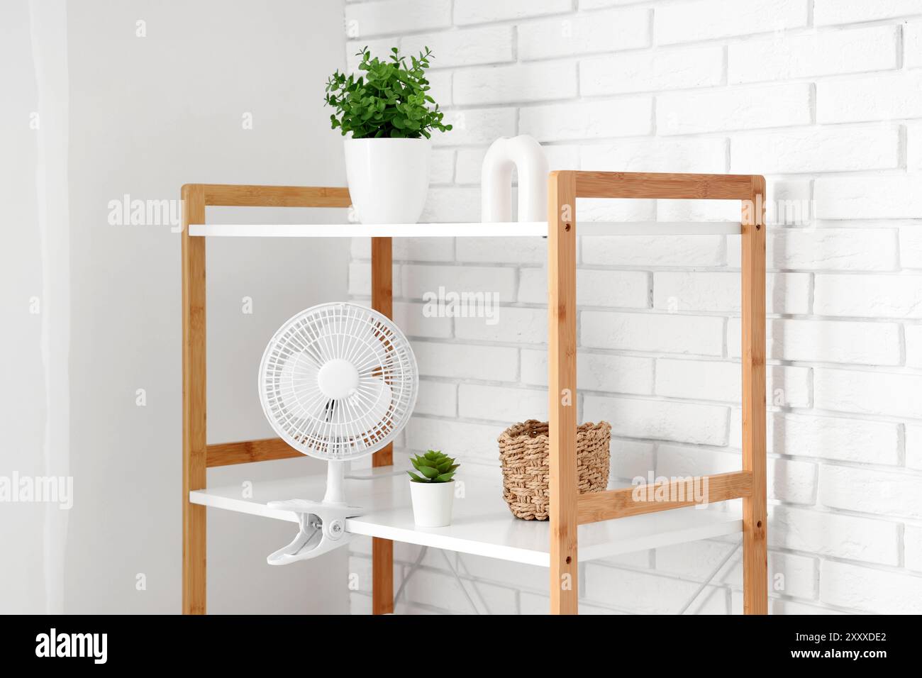 Modern electric fan on shelving unit in living room Stock Photo - Alamy
