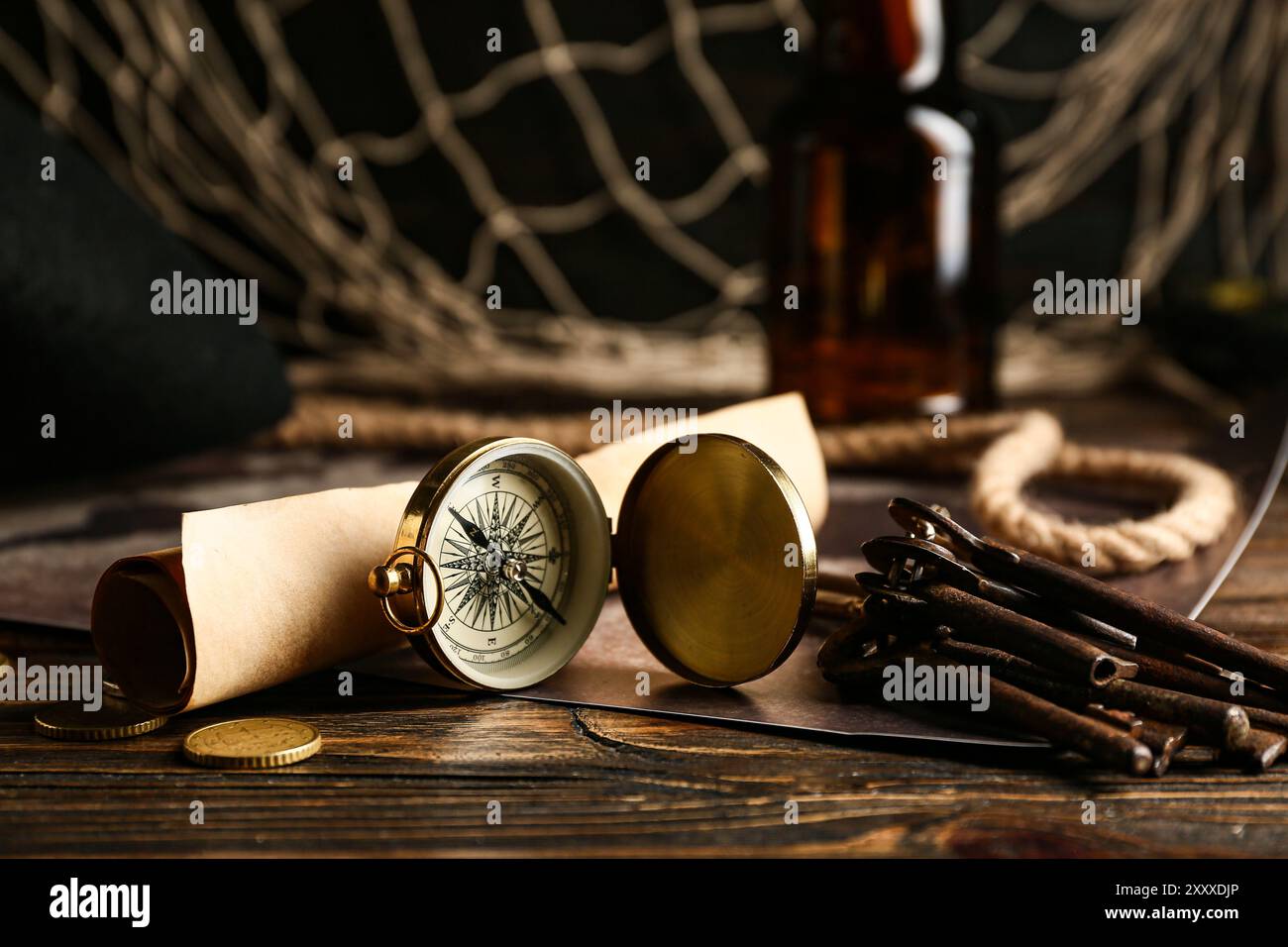Compass with old keys, treasure map and coins on wooden table, closeup ...