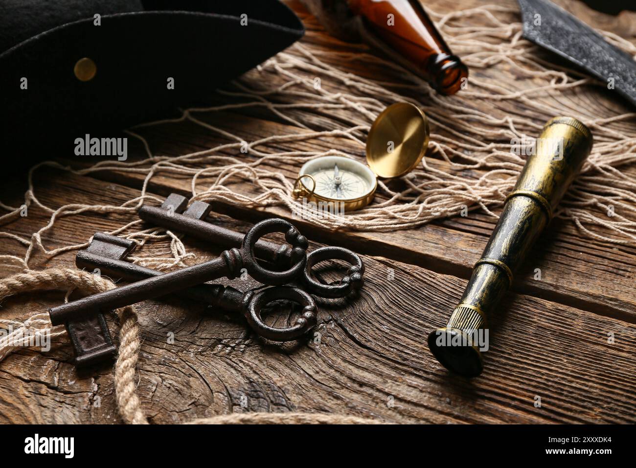 Old keys with compass, spyglass and net on wooden background, closeup ...