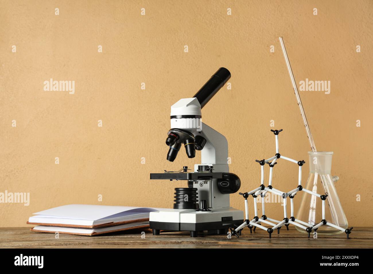 Modern microscope with chemical flask, molecular model and book on ...