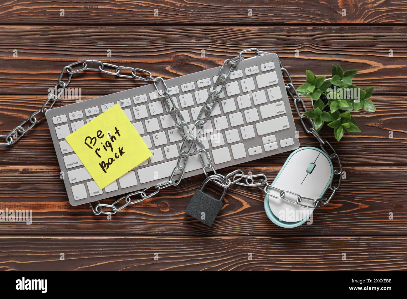 Sticky note with text BE RIGHT BACK, computer keyboard, chain and ...