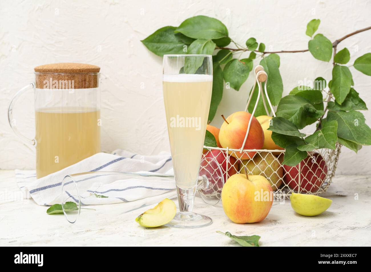 Glass and jug of fresh apple kvass on white background Stock Photo - Alamy