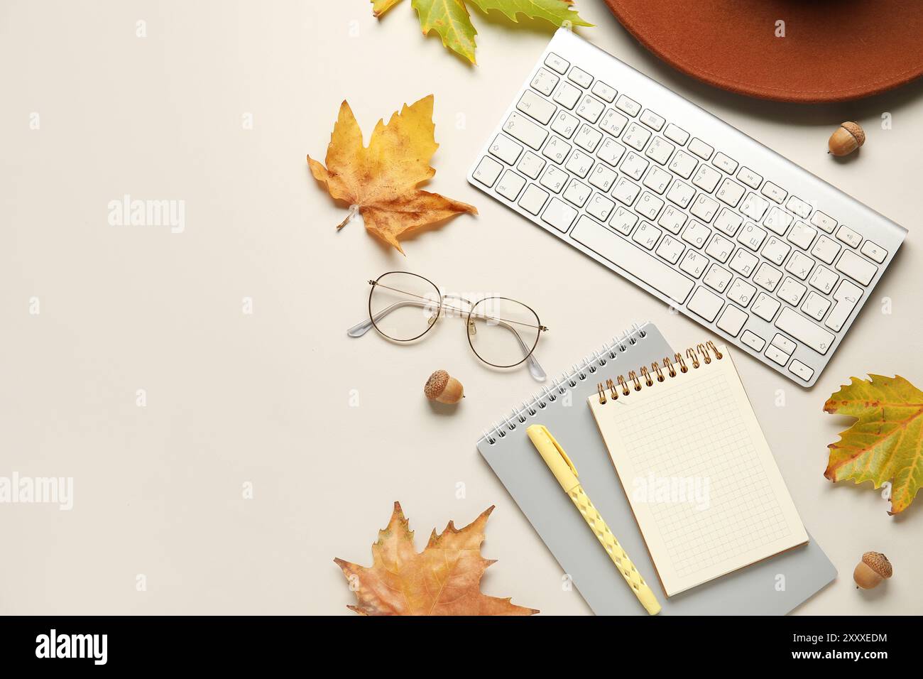 Composition with computer keyboard, notebooks, eyeglasses and autumn ...